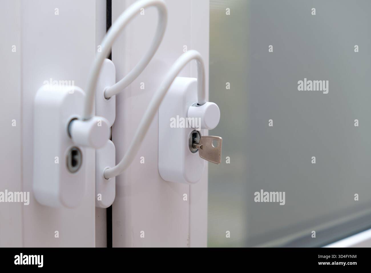 White window catch lock on a door with a key. Childproofing and home ...