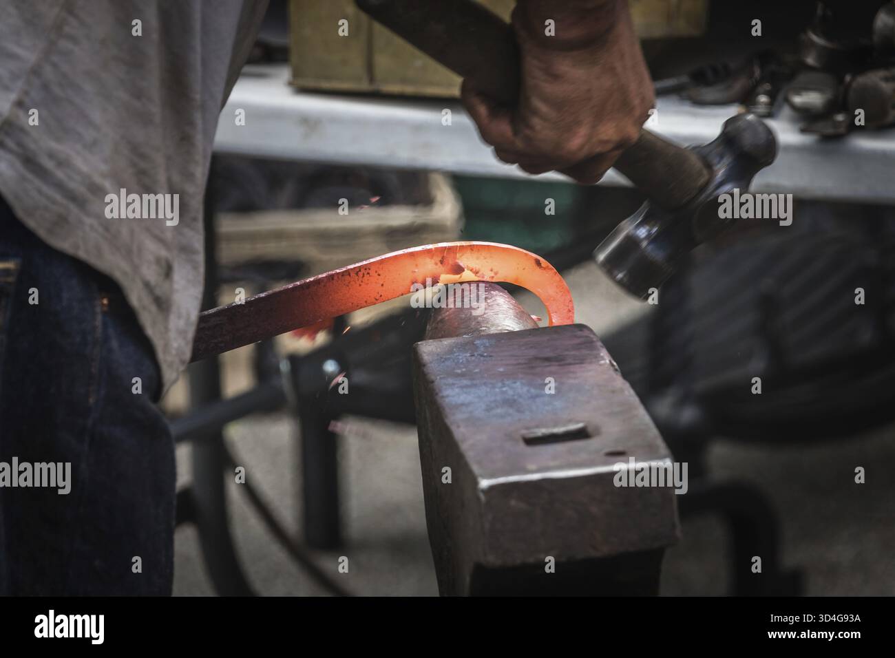A blacksmith hammering hot iron during medieval fair festival in ...
