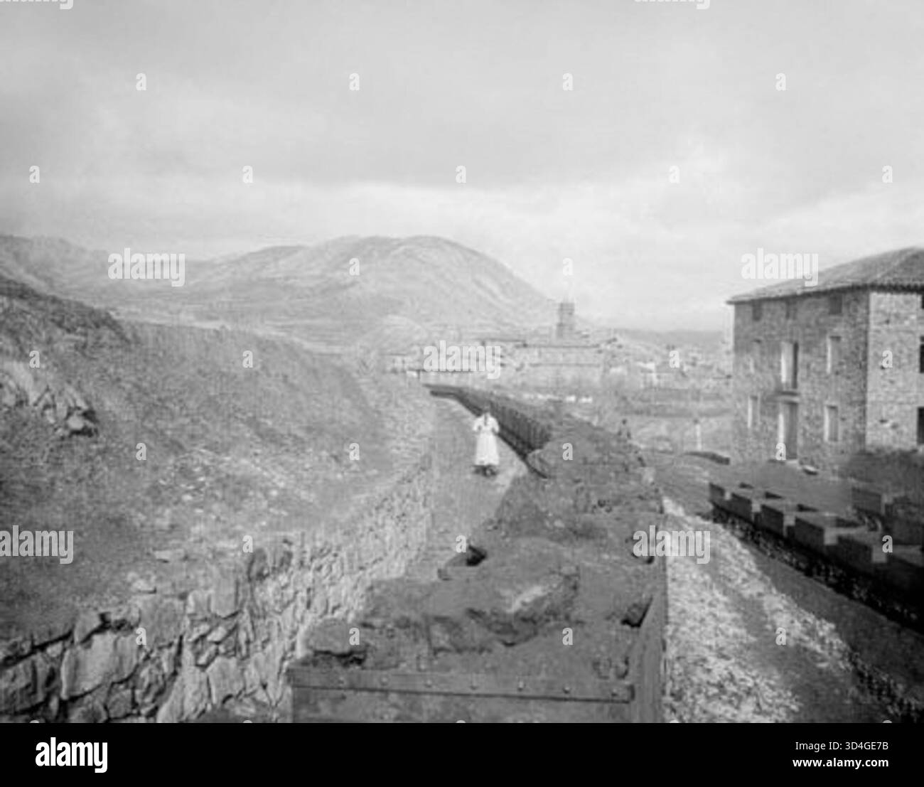 Restored image of a woman walking through the coal mine facilities of ...