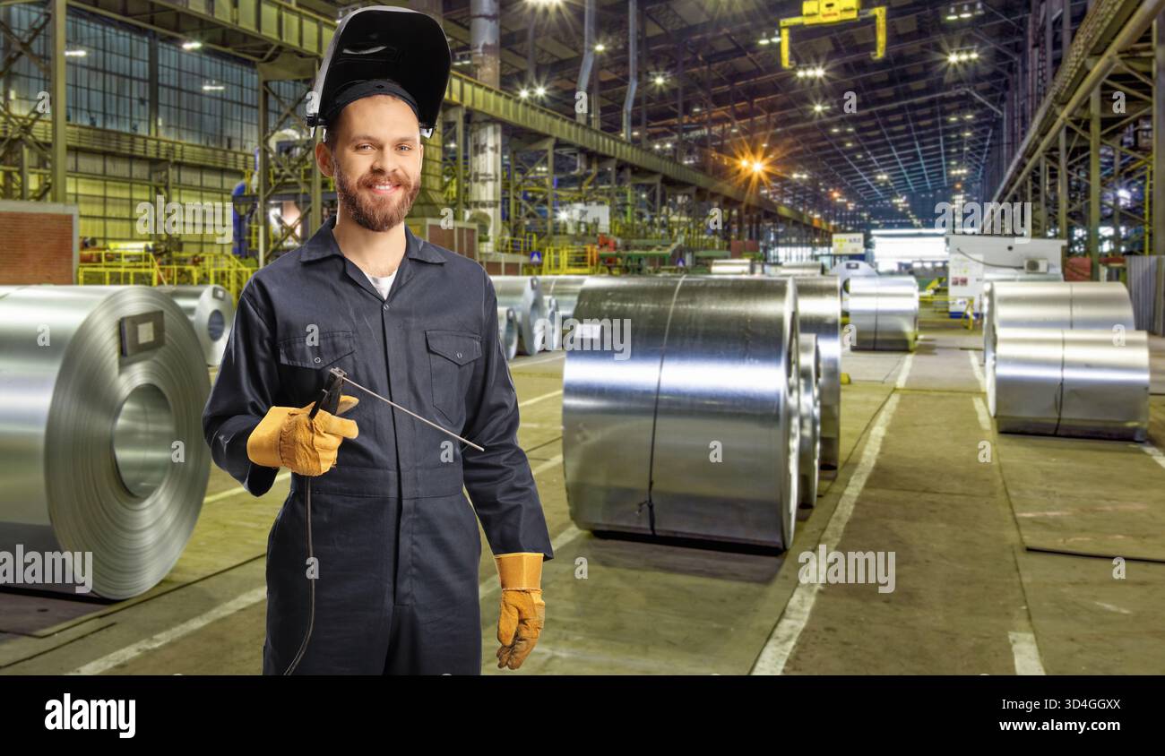 Welder with a shield and a welding machine at a steel mill Stock Photo ...