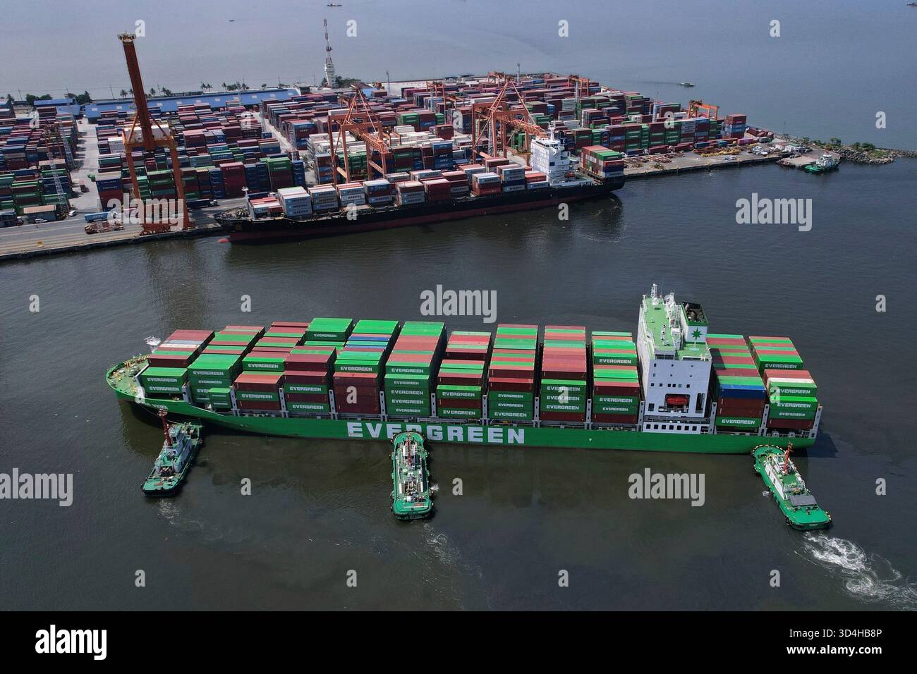 FILE - Tugboats assist a container ship as it prepares to dock at the ...