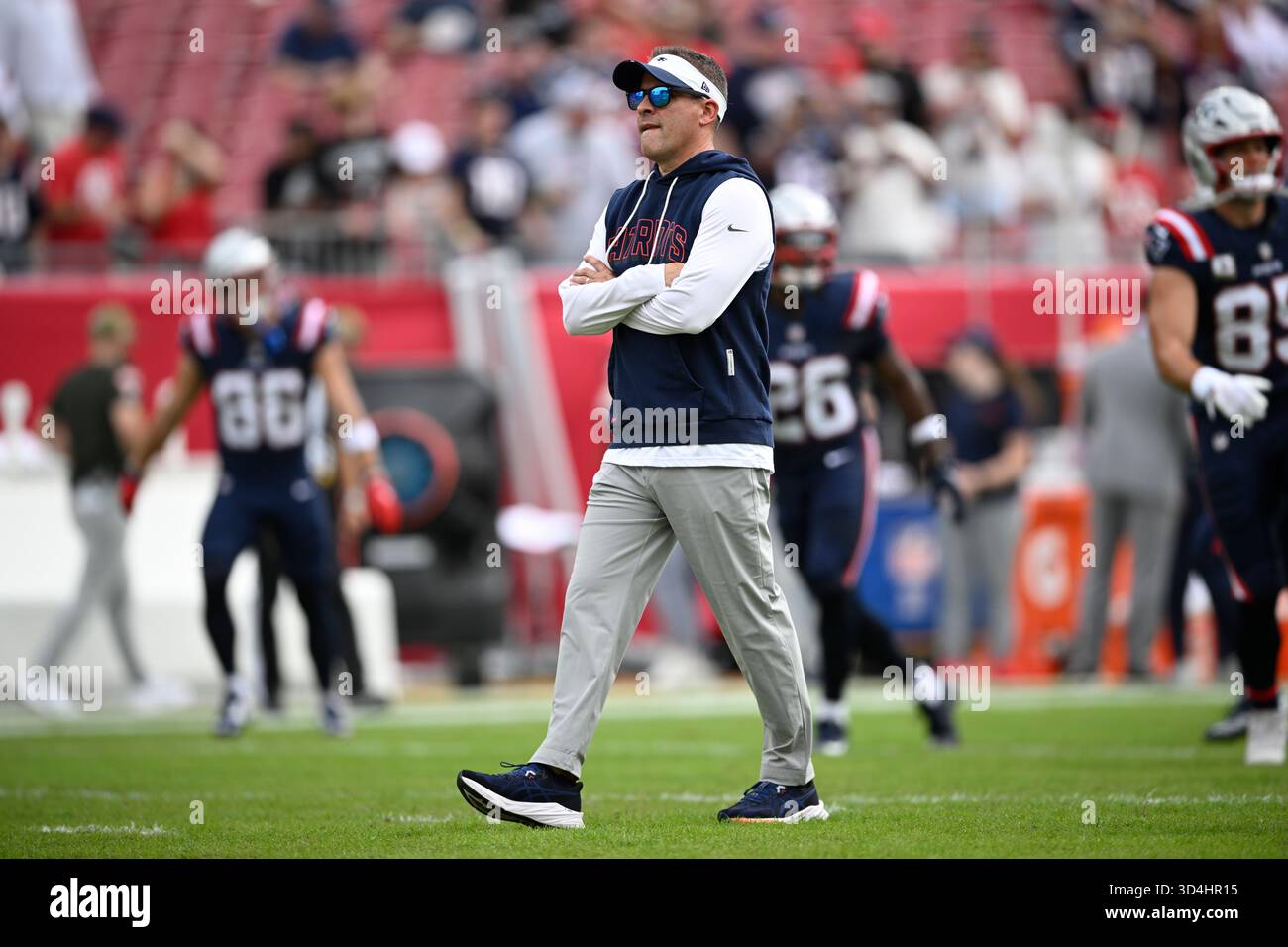 New England Patriots offensive coordinator Josh McDaniels, center, looks on as players warm up ...