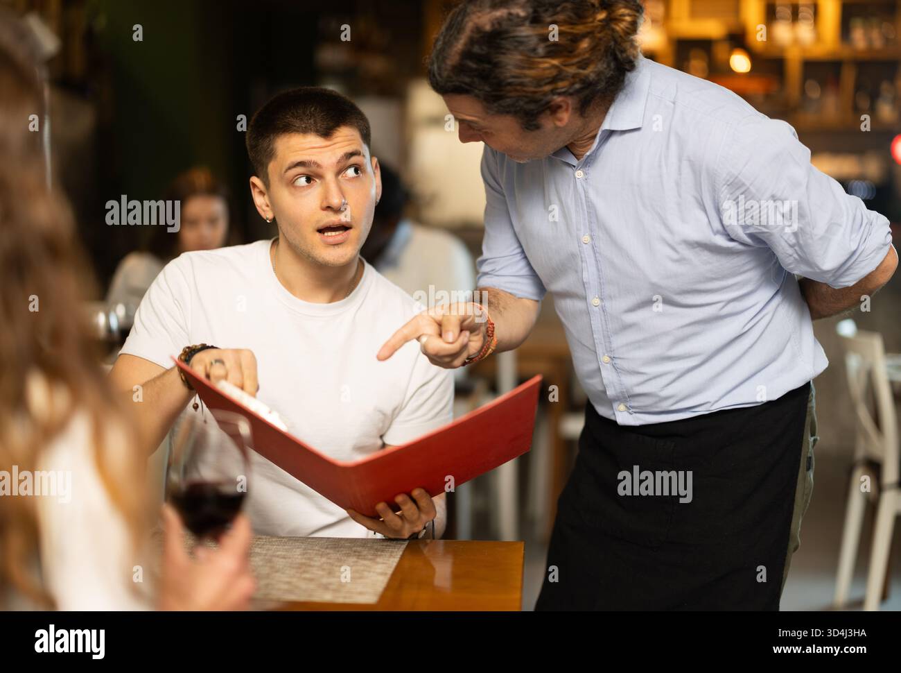 Waiter talks about menu selection in a restaurant Stock Photo - Alamy