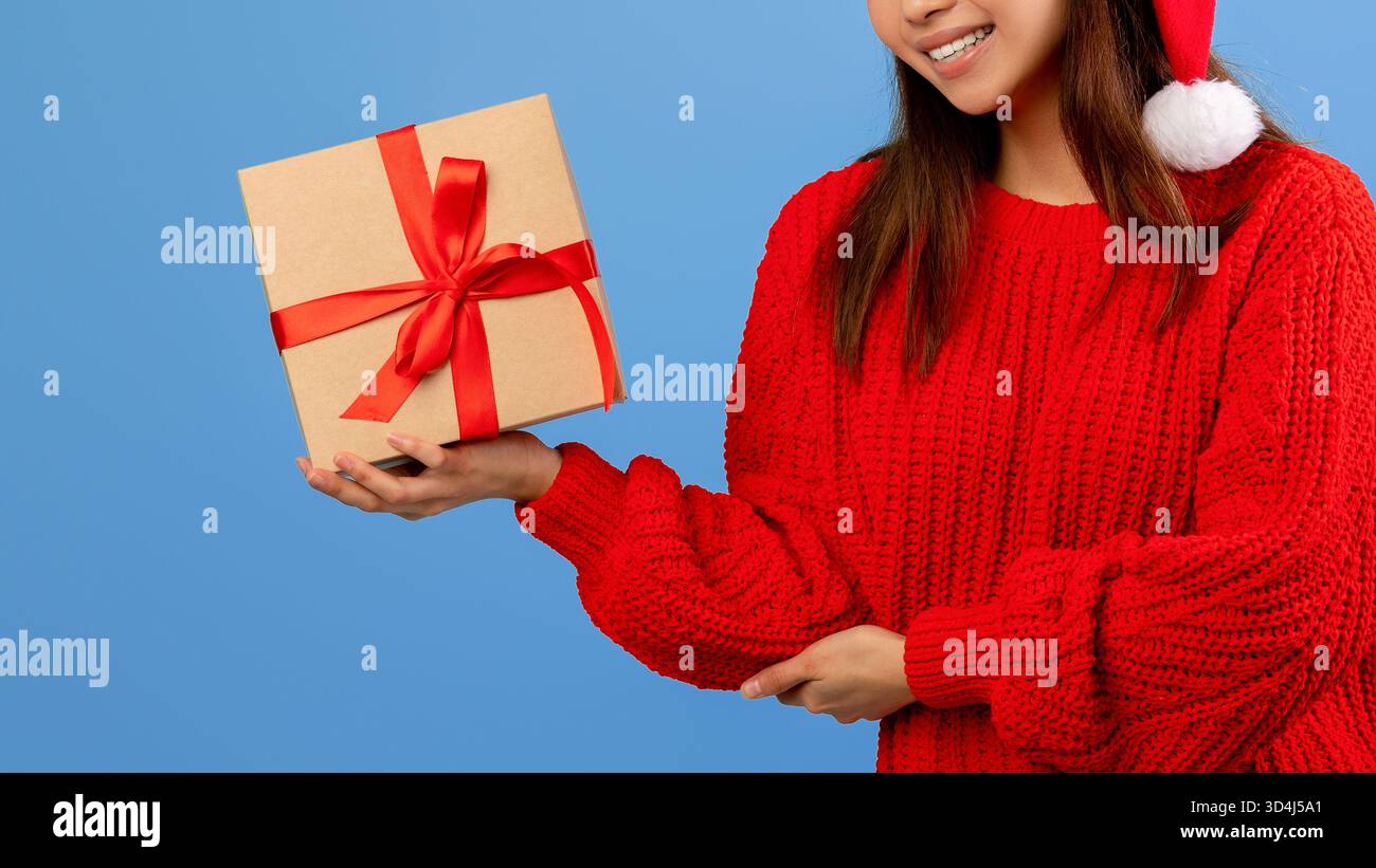 Young Woman in Festive Sweater Holding a Gift Box With Red Ribbon ...