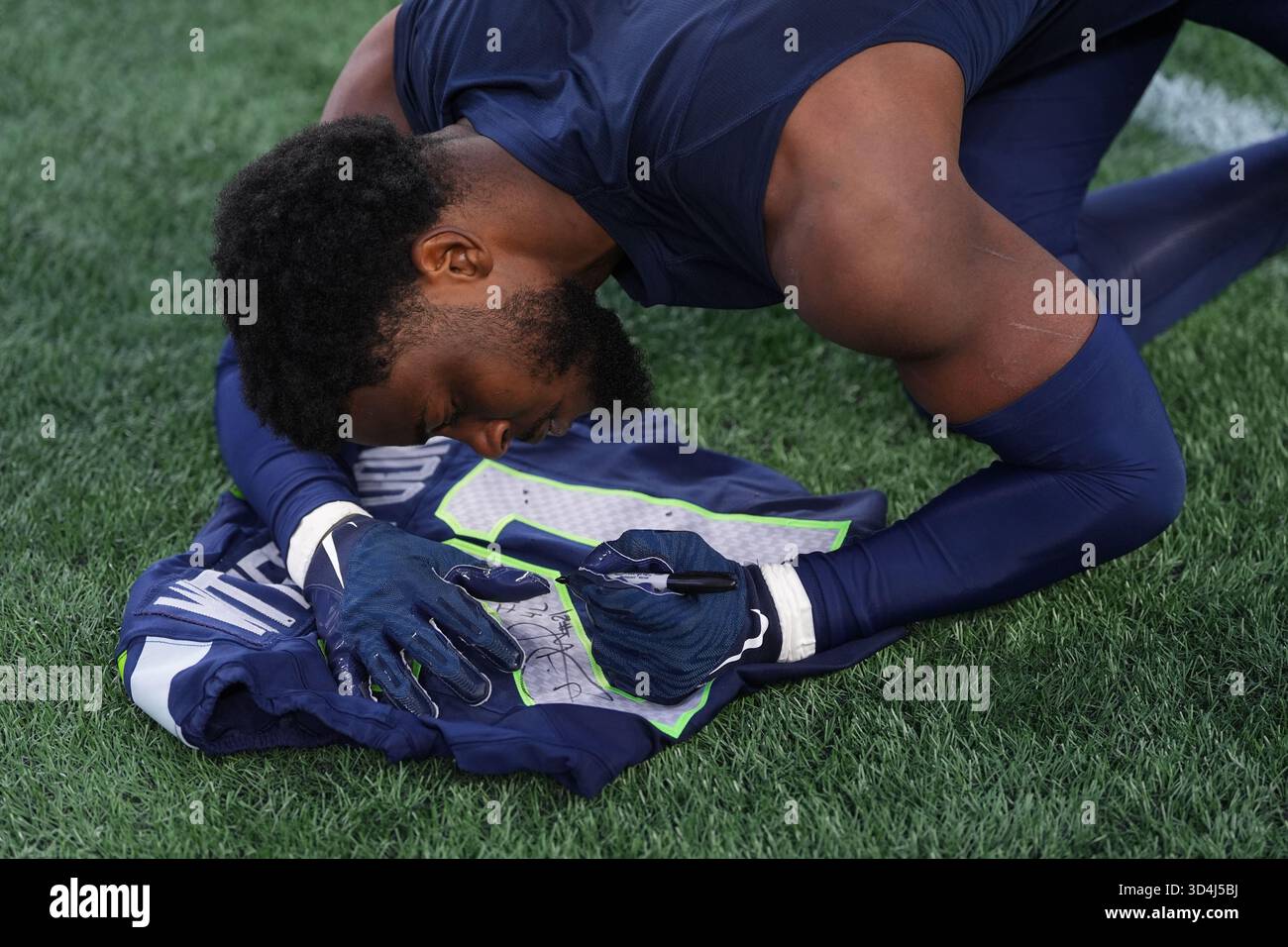Seattle Seahawks cornerback Devon Witherspoon signs his jersey before ...