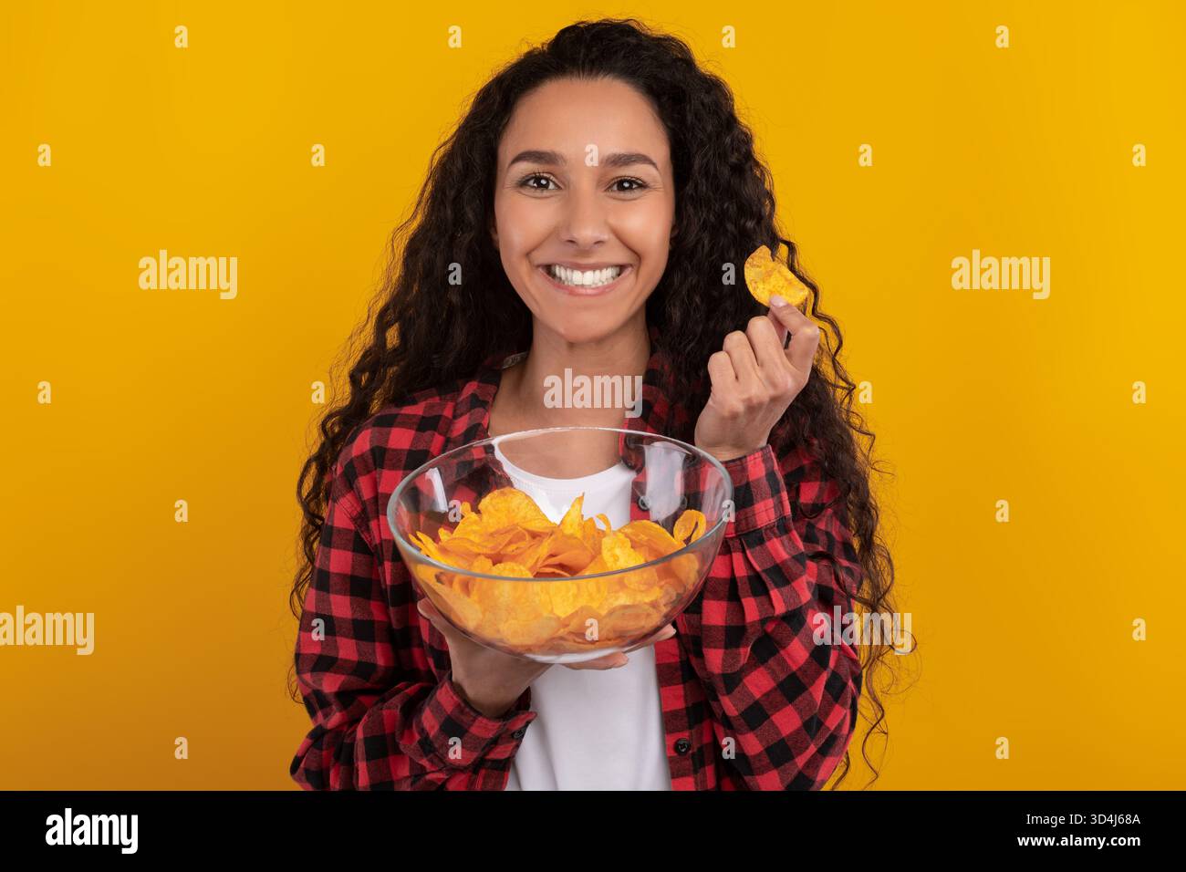 Excited Young Lady Enjoying Crispy Potato Chips in a Bright Studio ...