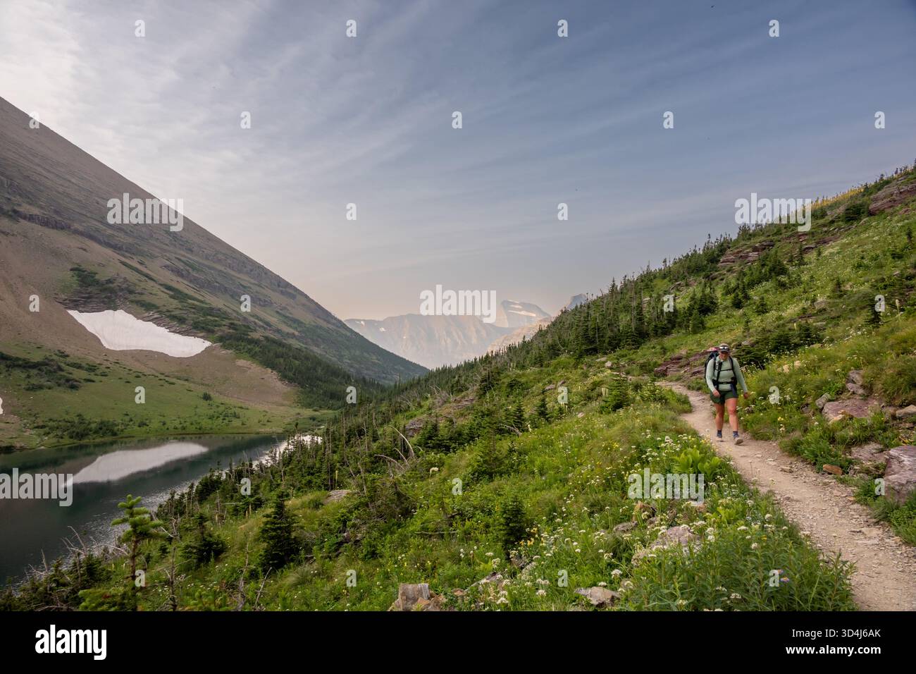 Backpacker Passing Ptarmigan Lake In Glacier National Park Stock Photo ...