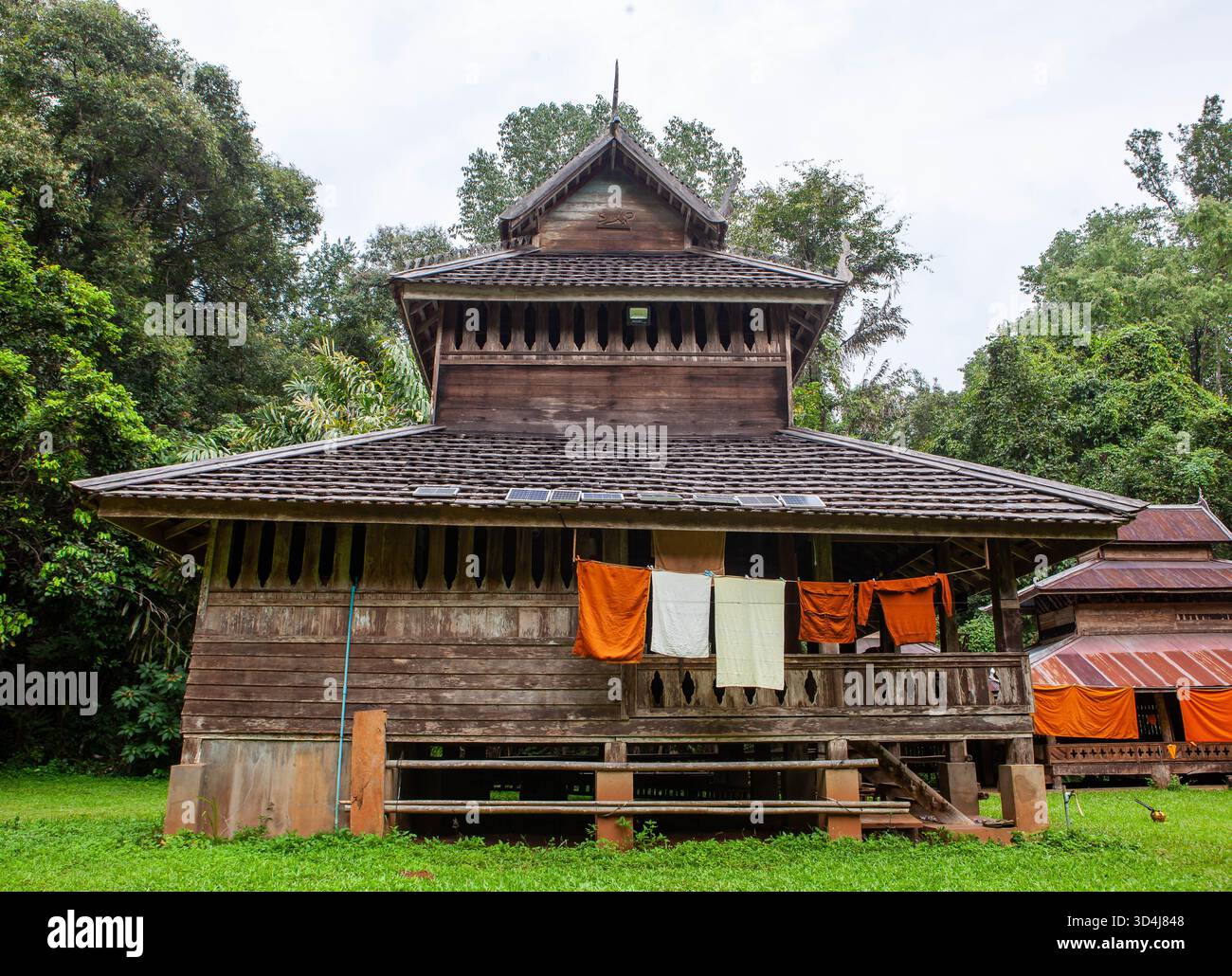 Old wooden buildings with Buddhist monks' robes hung out to dry at Wat ...