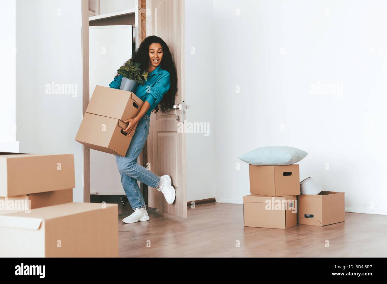 Moving Into a New Home With Boxes and a Plant in Hand, Ready for a ...