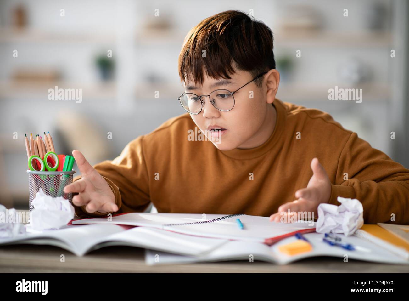 Korean Teenager Struggles With Homework at a Table in a Cozy Home ...