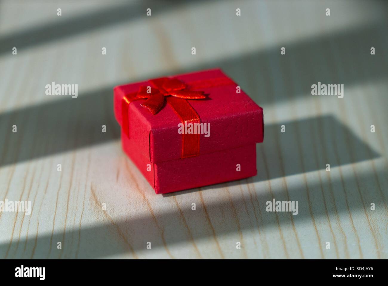 Small red gift box with ribbon placed on a wooden table. Concept of ...