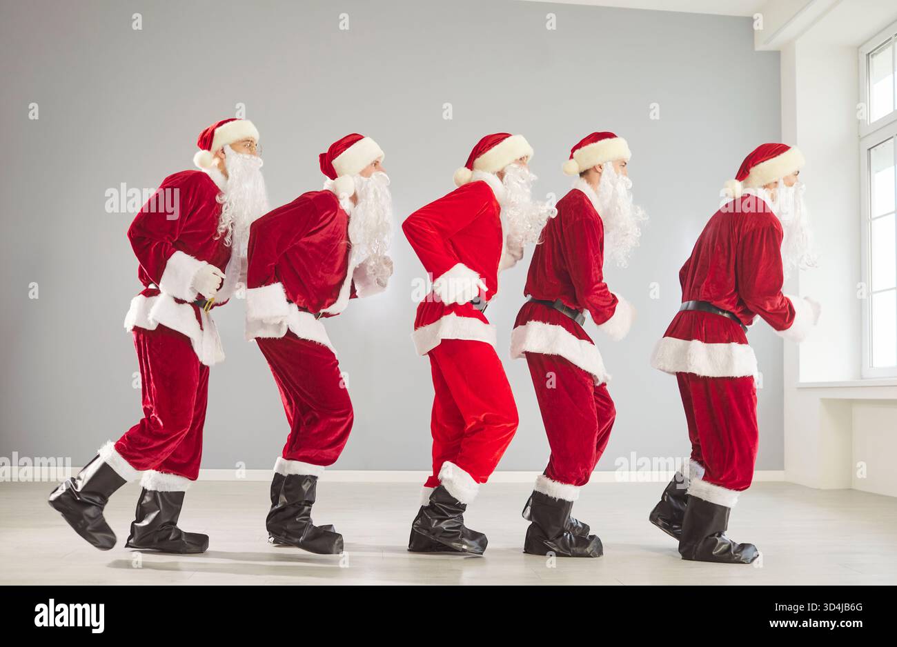 Dancing funny cute male group wearing red Santa Claus suits humorous ...