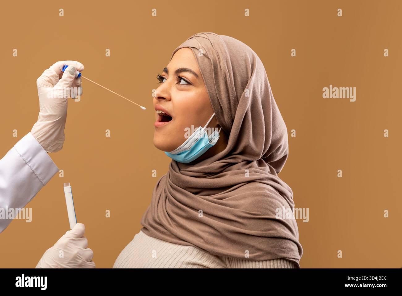 Muslim woman getting PCR oral coronavirus swab test, female doctor ...