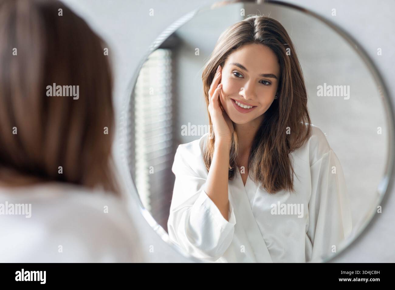 Young Woman Enjoys Self-Care Routine While Admiring Her Reflection in ...