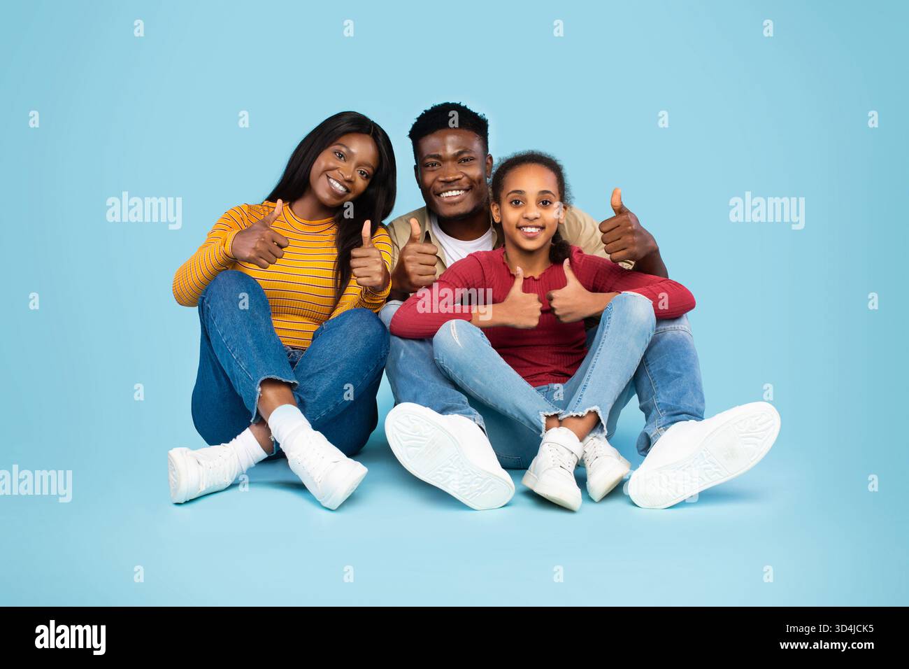 Family of Three Sharing Joy and Approval With Thumbs up in Blue Studio ...