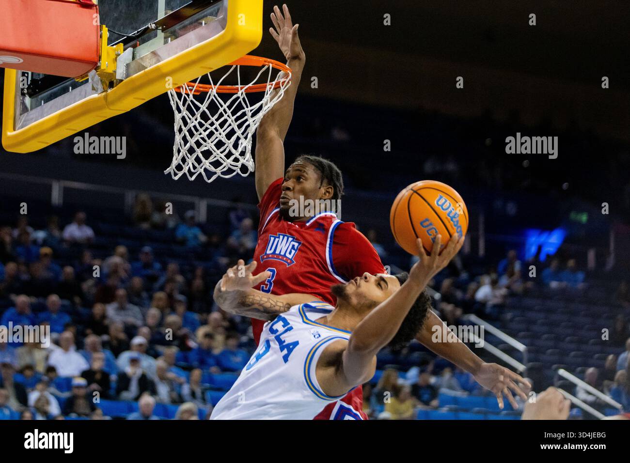 UCLA guard Eric Freeny, bottom, goes to the basket while defended by ...
