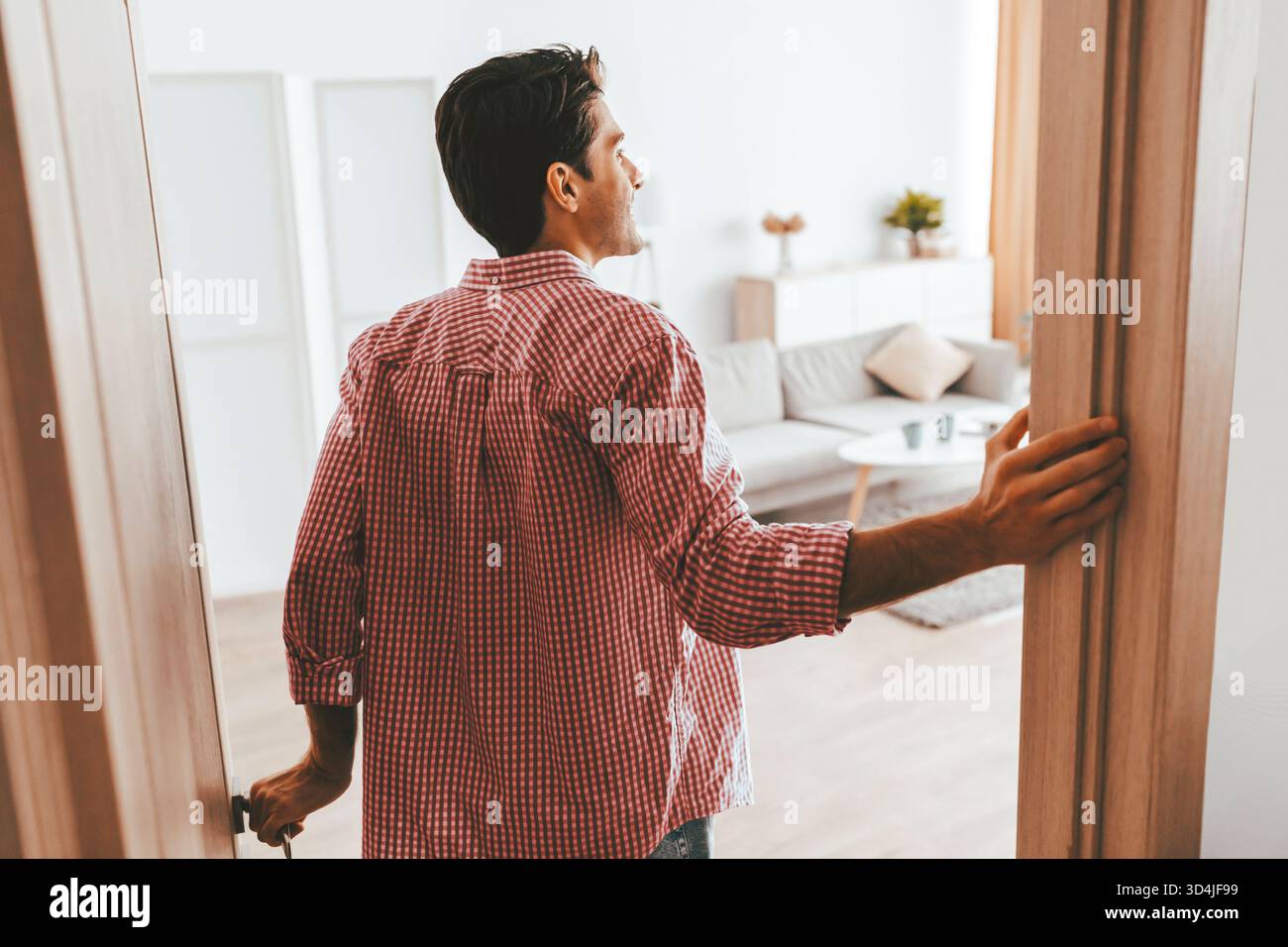 Man Opening Door to Modern Living Room in Bright, Spacious Apartment in ...