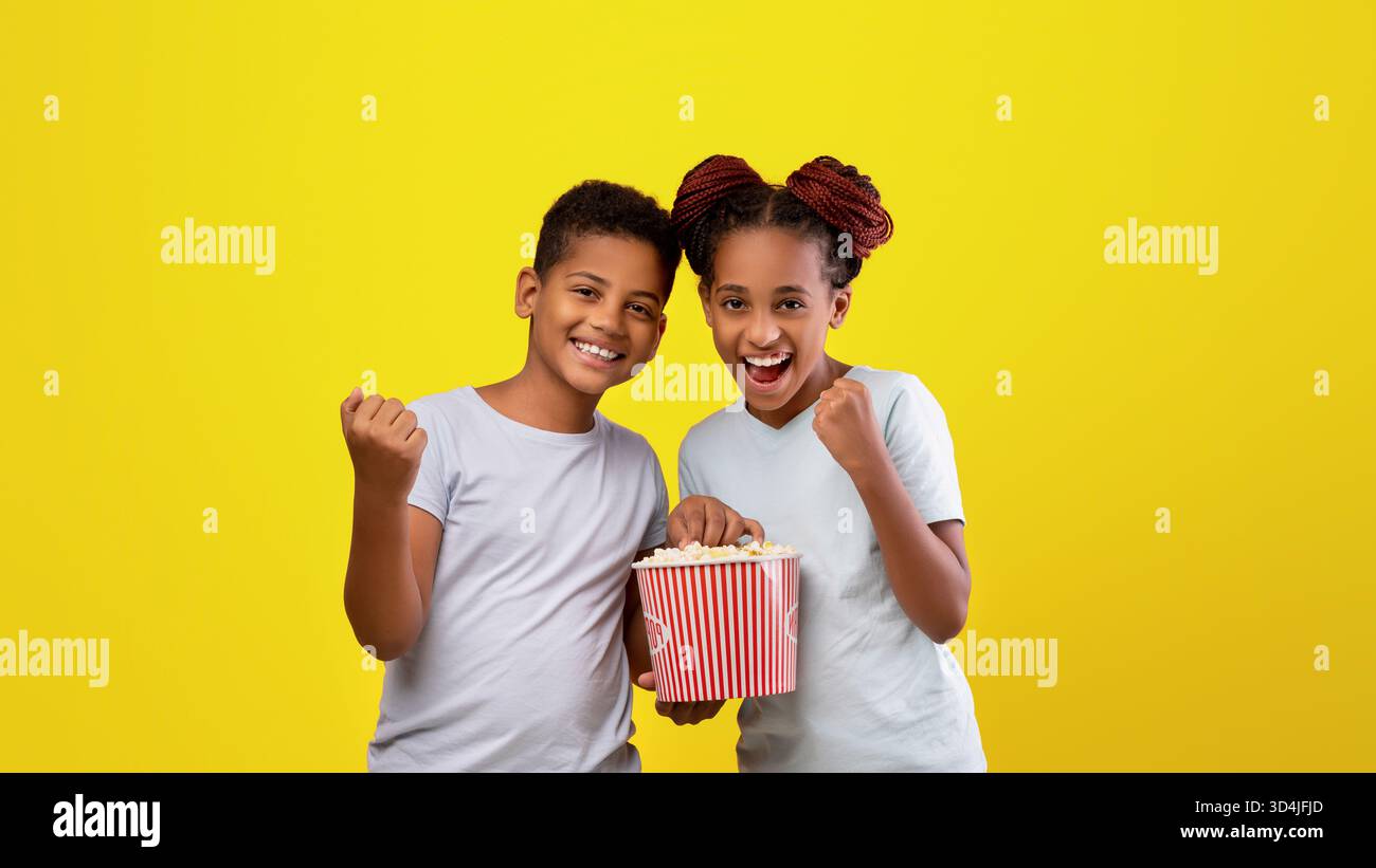 Kids Enjoy Popcorn While Celebrating in Front of a Bright Yellow ...