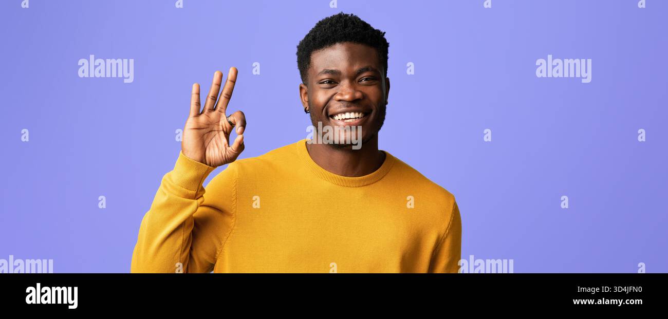 Smiling Man Showing Okay Gesture Against a Purple Background in a ...
