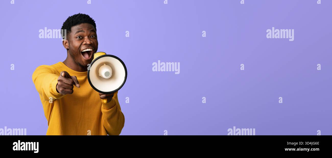 Man in Yellow Sweater Cheerfully Points While Holding a Megaphone ...