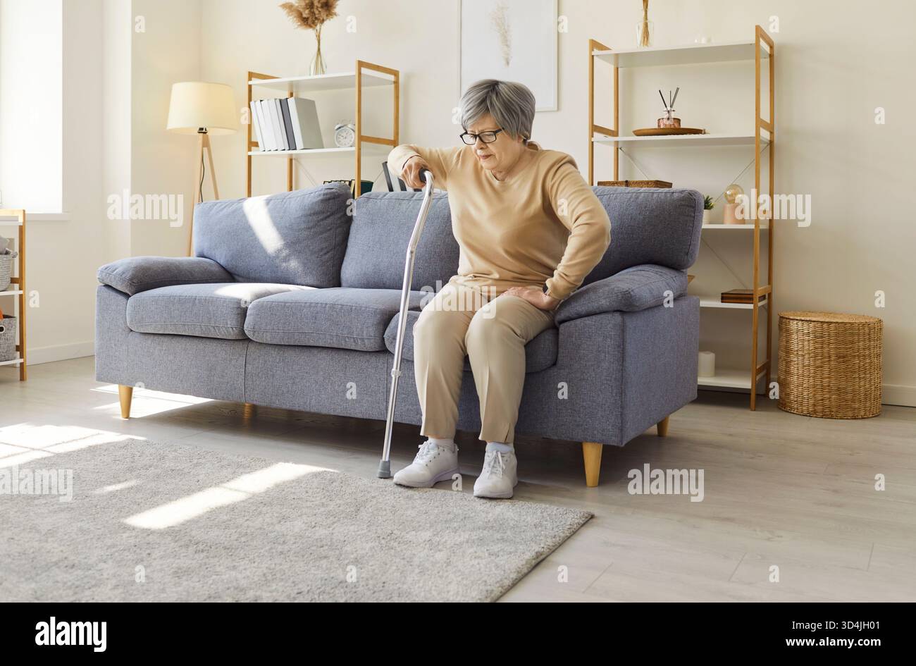 Senior elderly woman getting up from the couch with the help of her ...