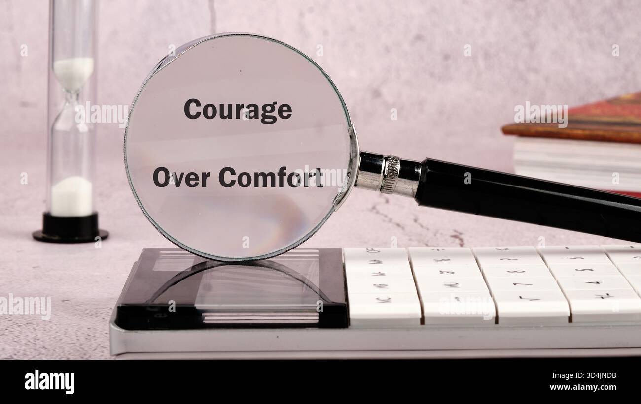 A magnifying glass highlights the phrase Courage Over Comfort on a ...