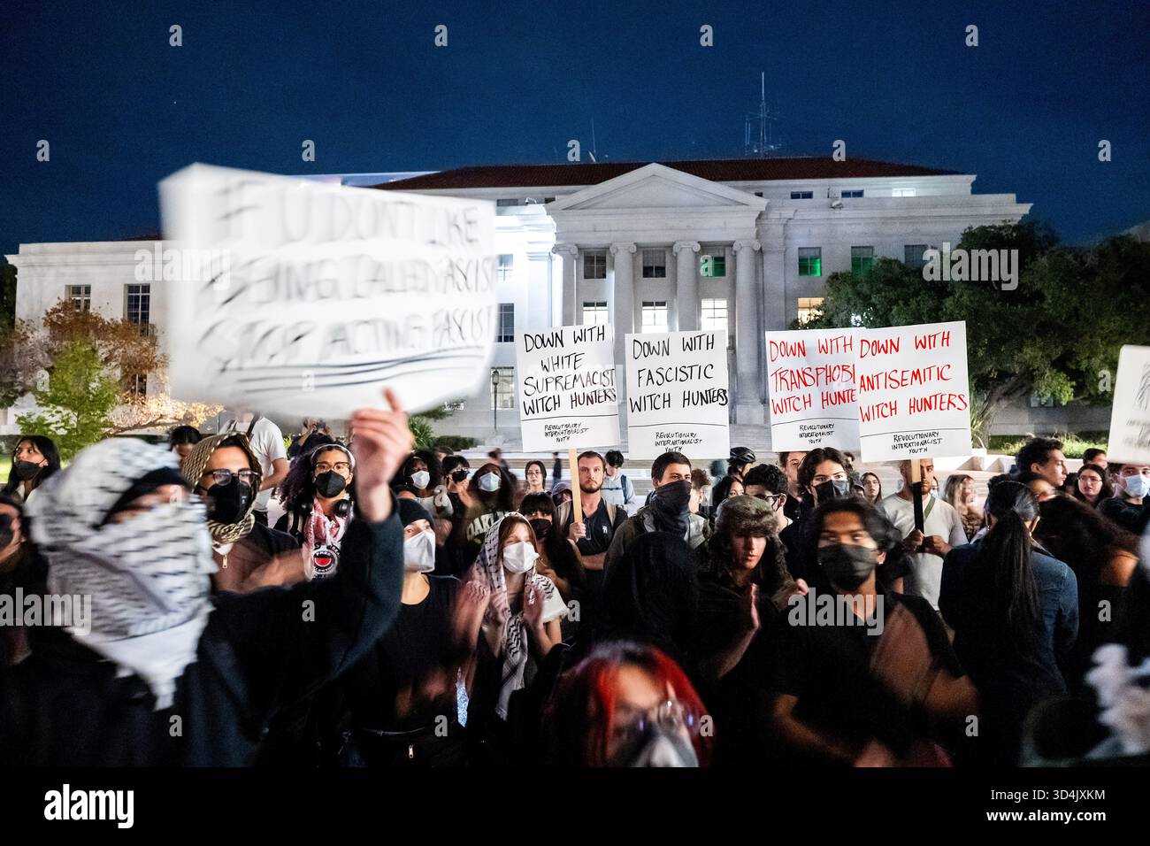 Protesters hold signs while demonstrating outside a Turning Point USA ...