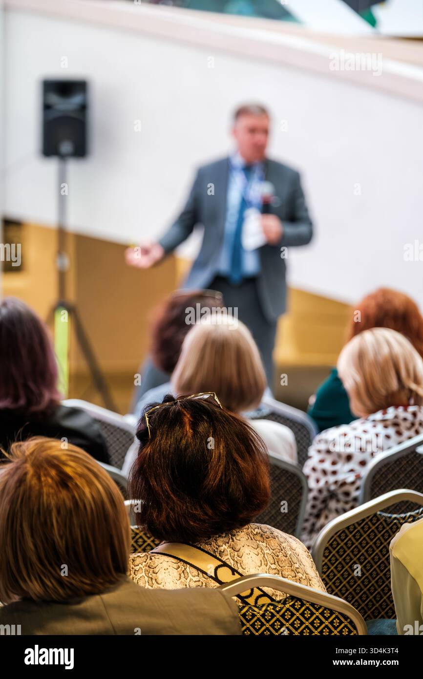 Blurred presenter speaks microphone conference hi-res stock photography ...