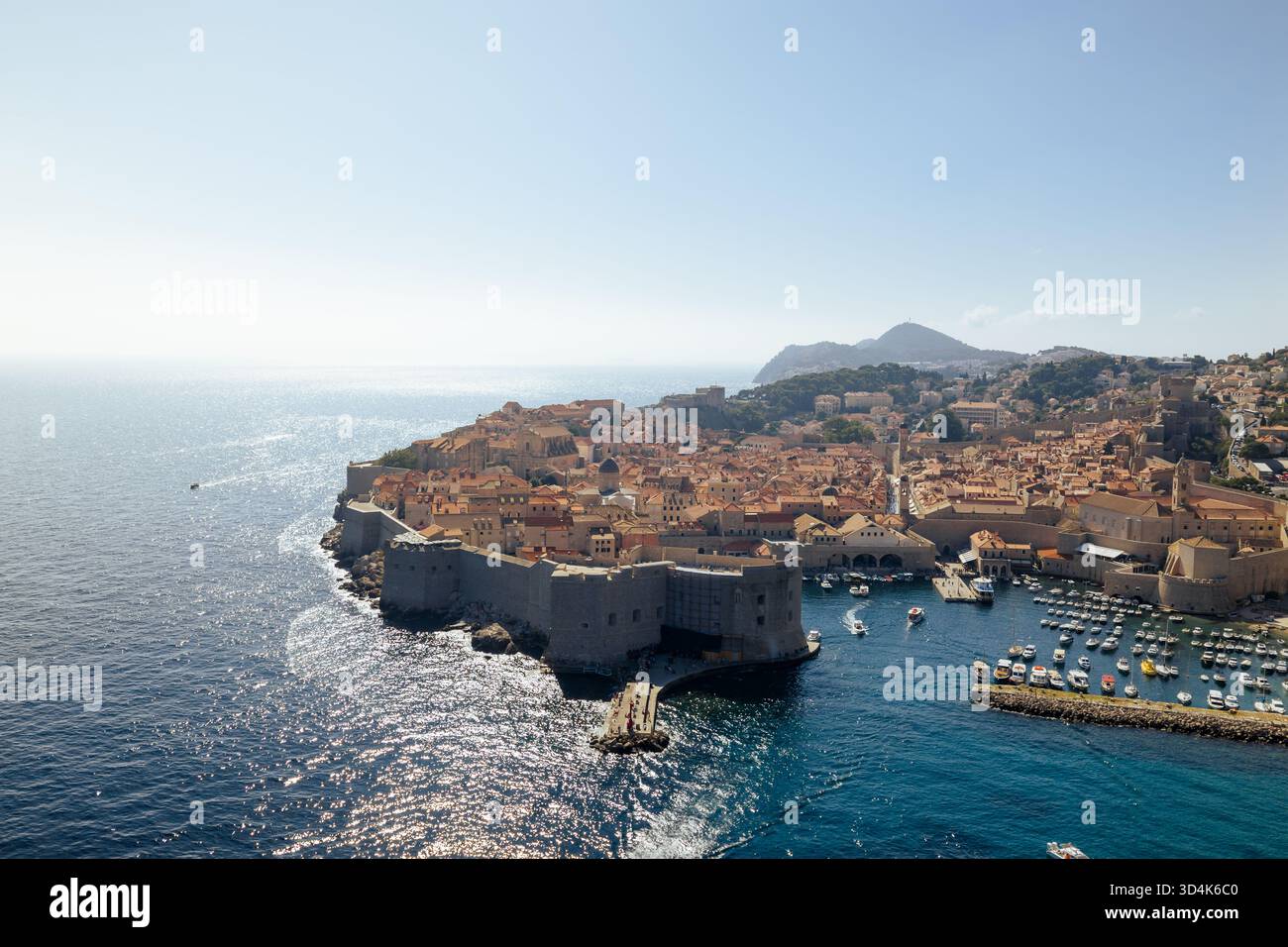 Aerial view of the sun-kissed terracotta rooftops meeting the azure ...
