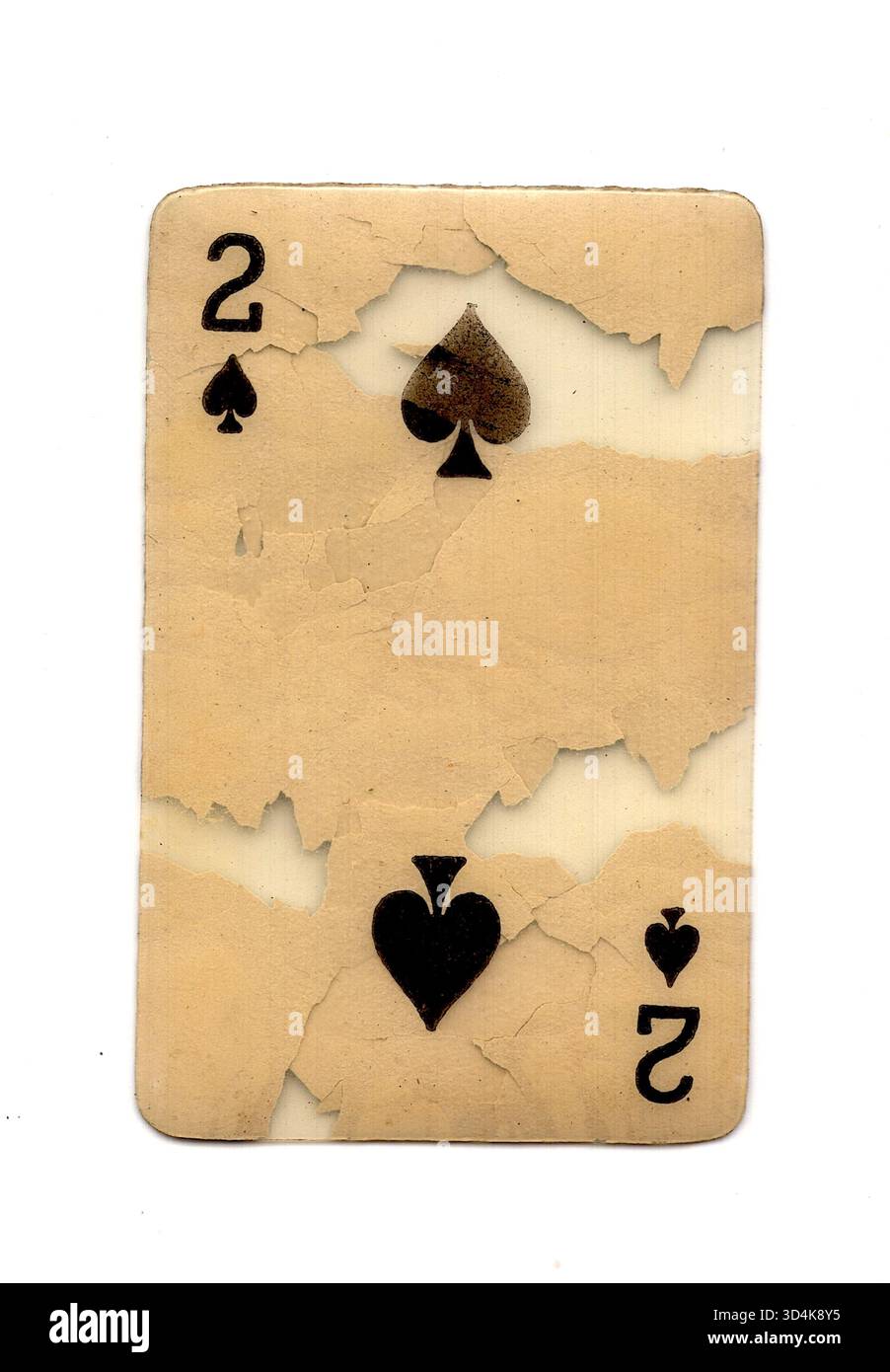 A badly damaged vintage playing card in the suit of spades isolated on ...