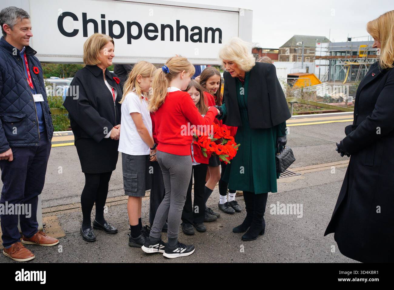 Queen Camilla is presented with a crocheted poppy wreath by Eira Jones ...