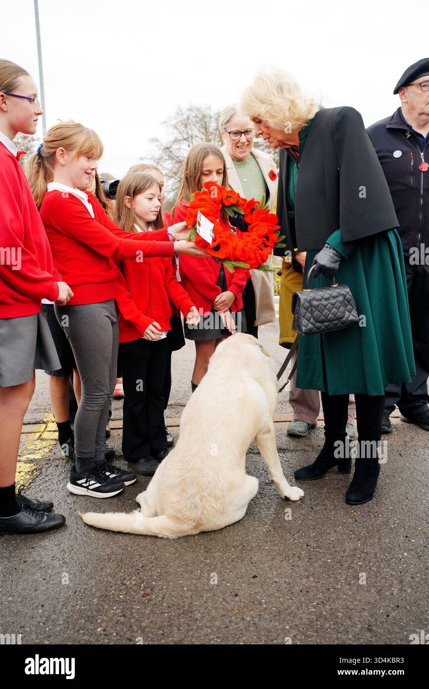 Queen Camilla is presented with a crocheted poppy wreath by Eira Jones ...