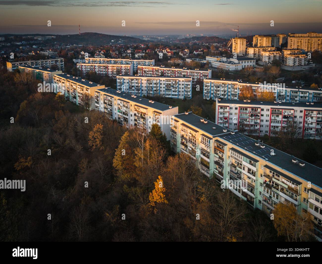 Aerial view of long apartment blocks cascading down a wooded slope ...