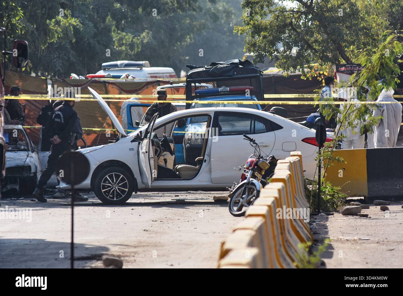 Pakistan's investigators examine the site following a suicide bombing ...