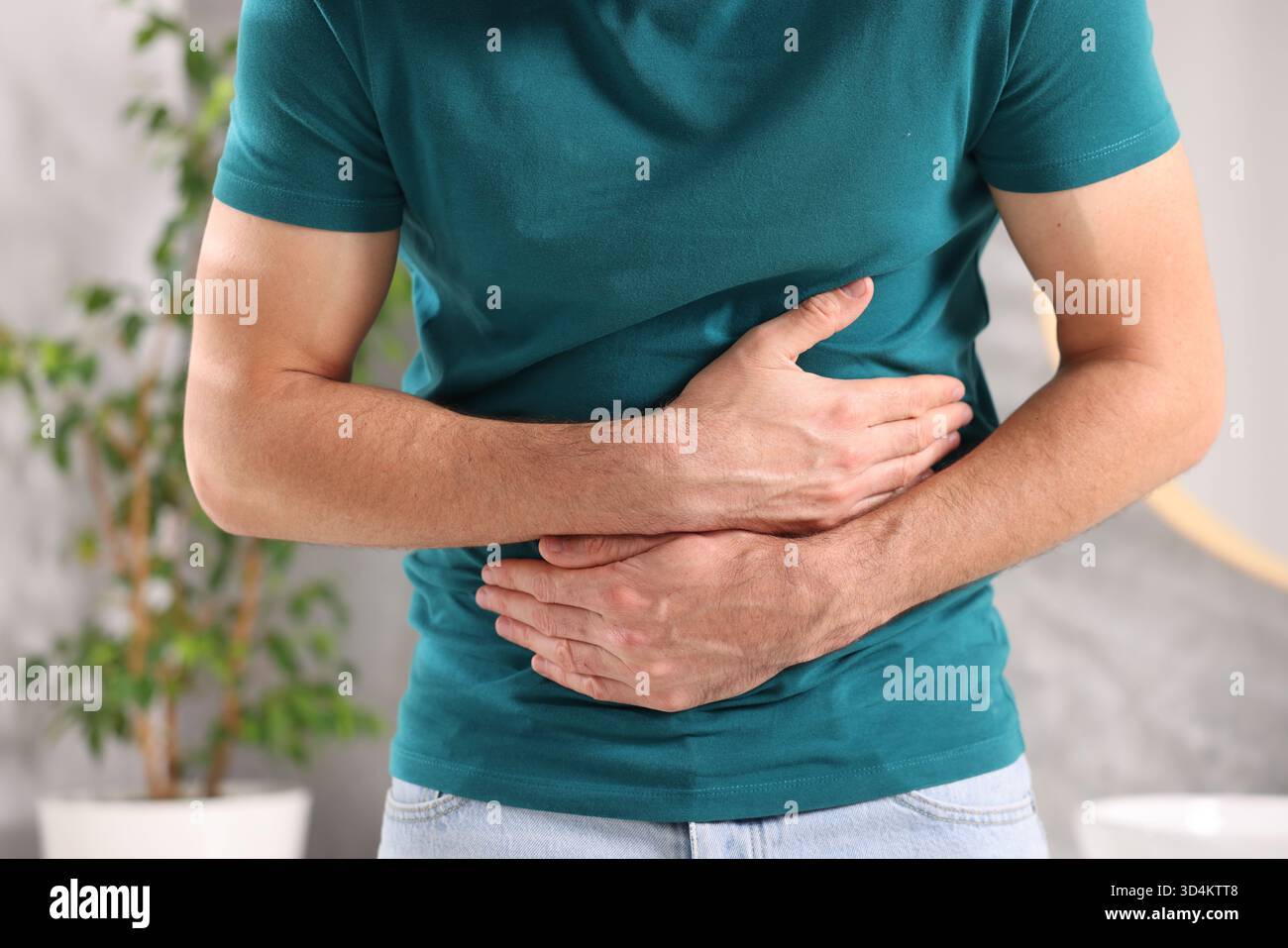 Man suffering from stomach ache and nausea in bathroom, closeup Stock ...