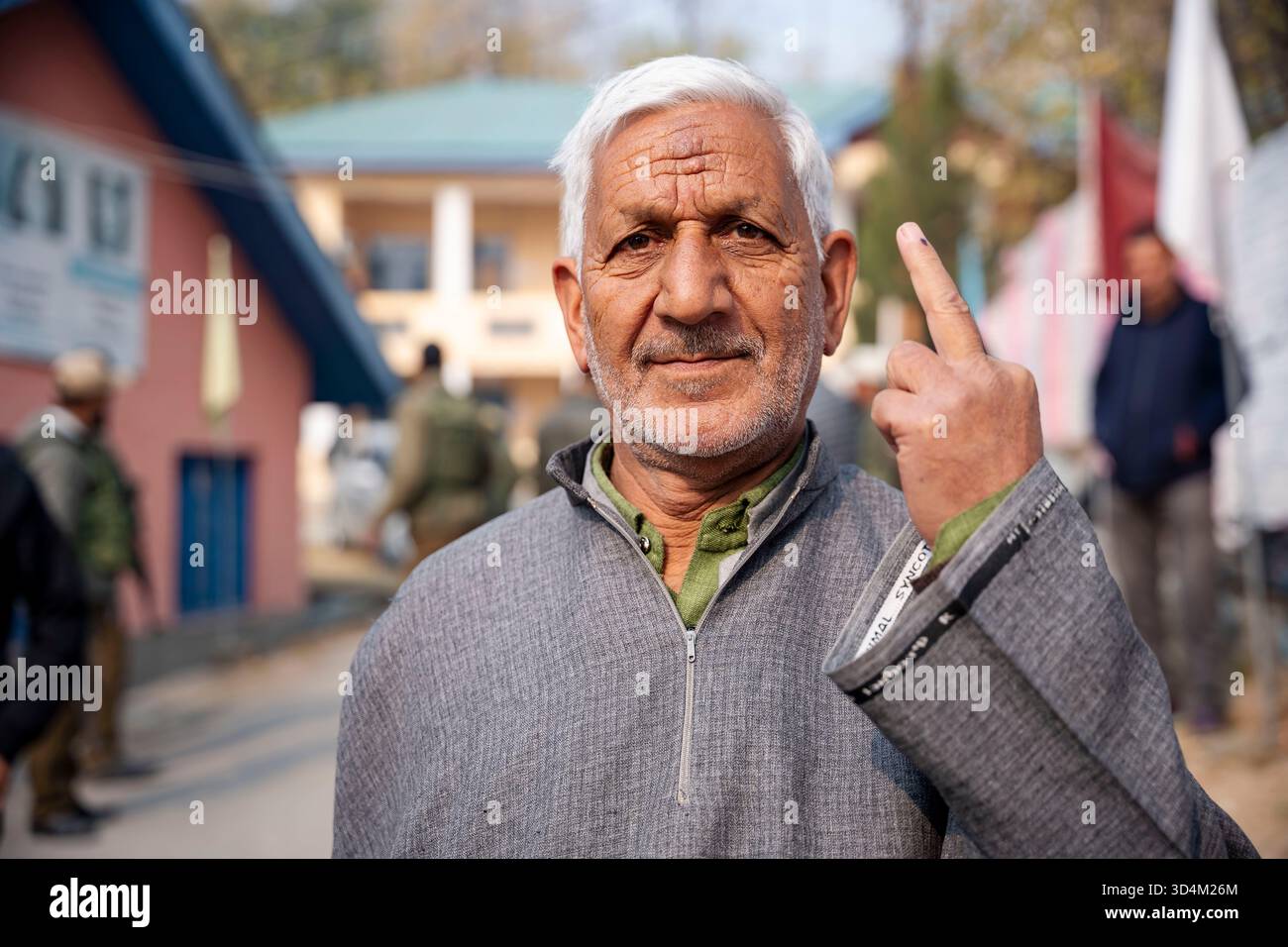 A voter shows the ink mark on his finger after casting his vote outside ...