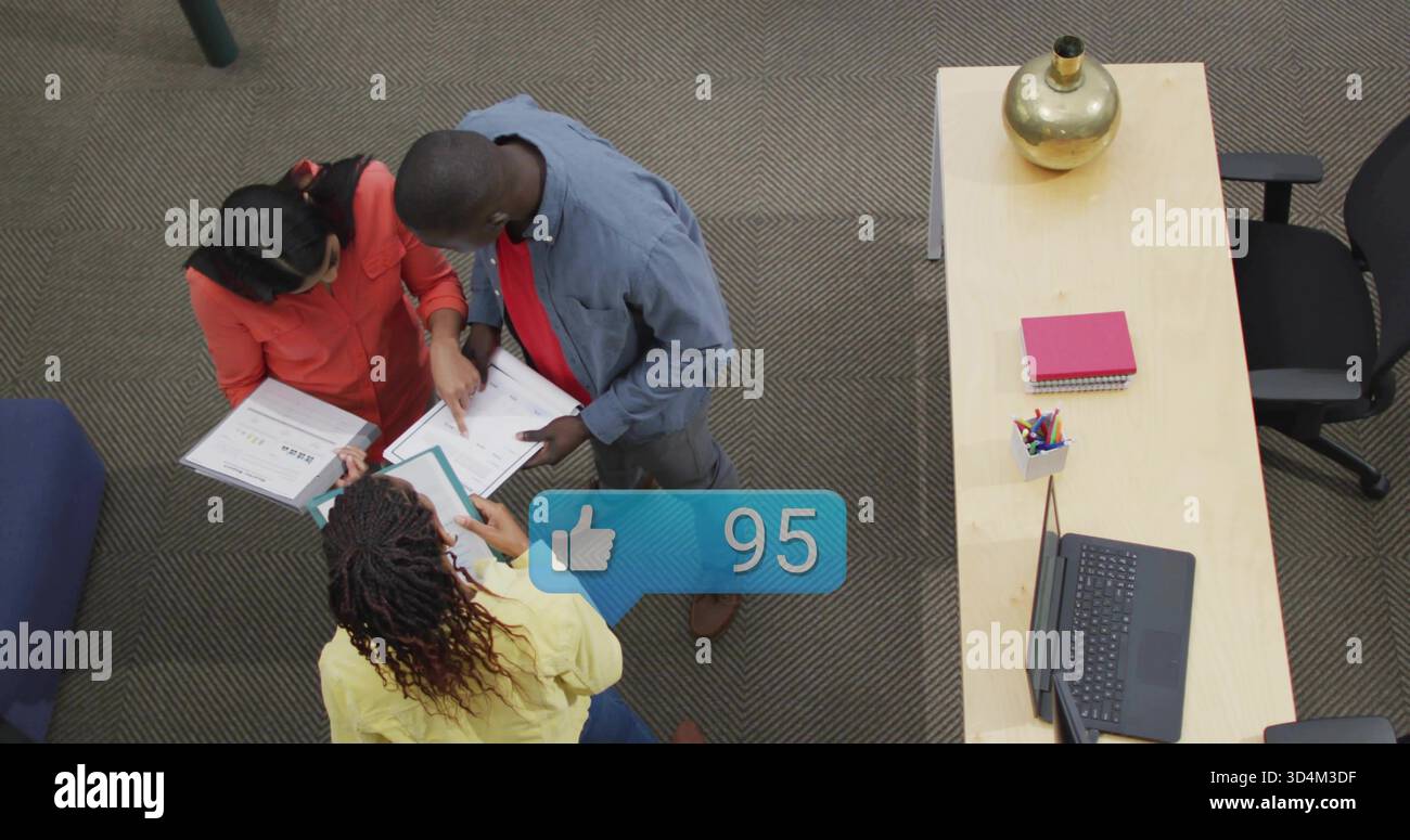 Reviewing three team members examining documents on office floor with ...