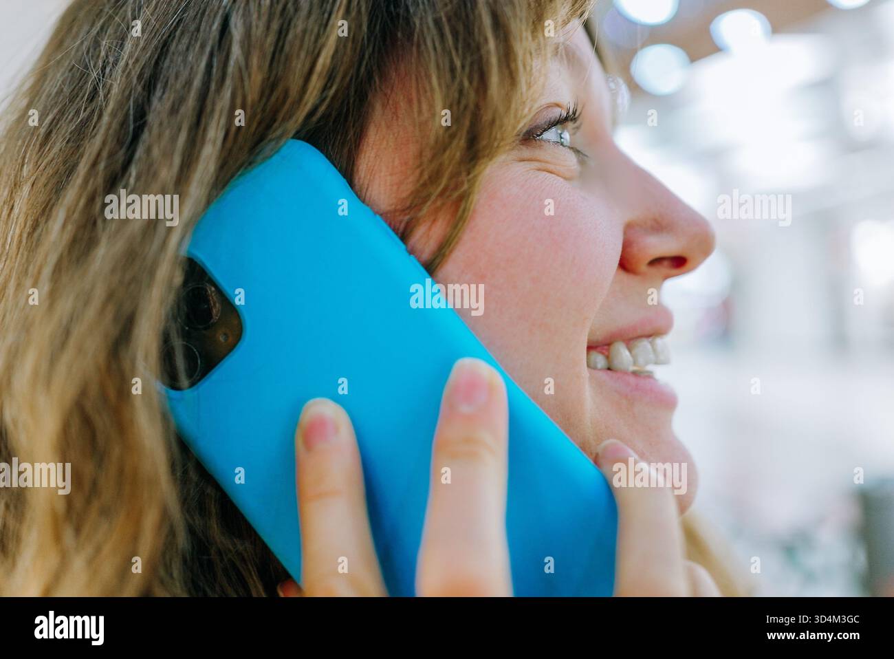 Smiling woman talking on a smartphone, enjoying a conversation and ...