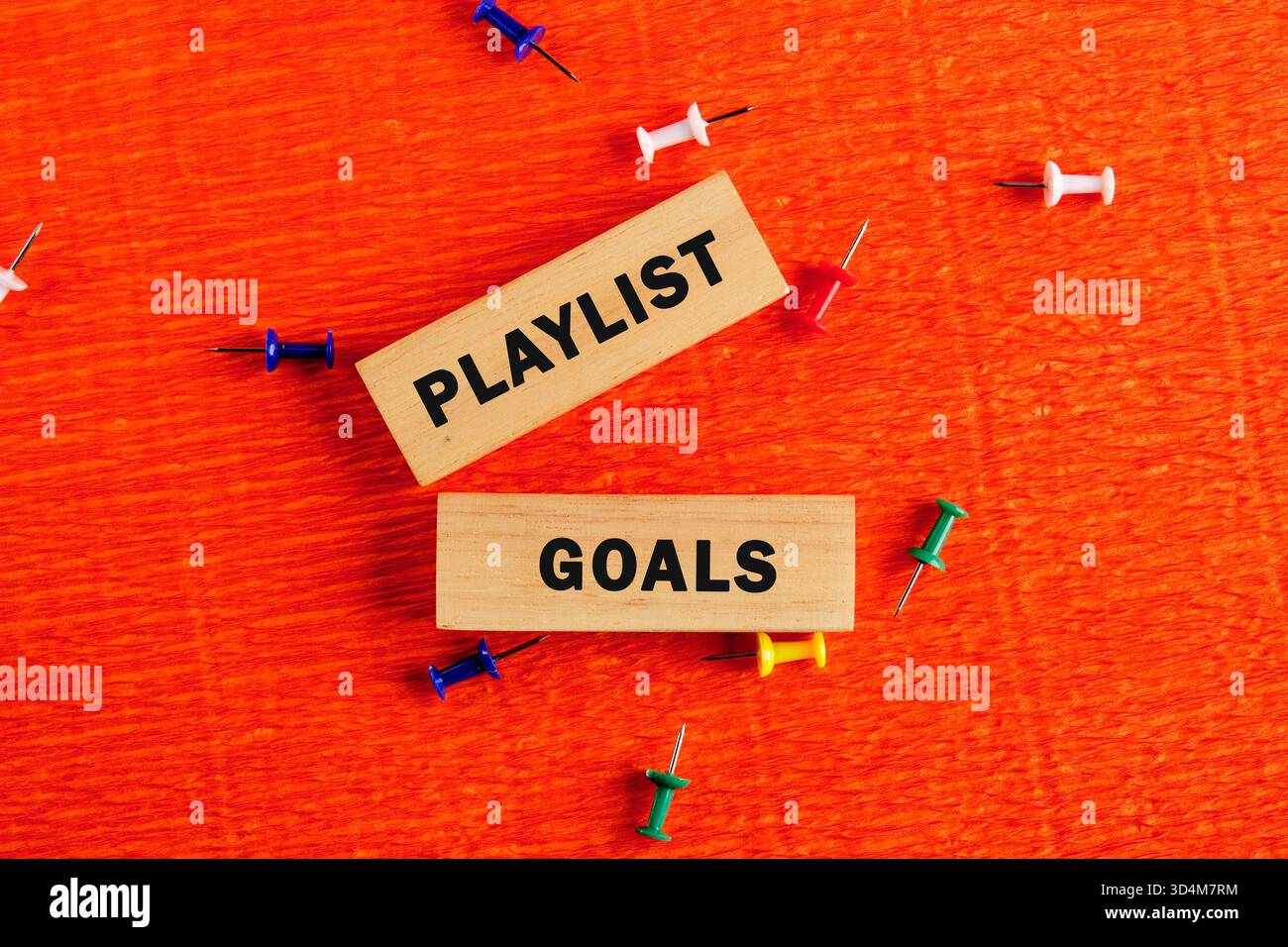 Two wooden blocks with the words playlist and goals are set against a ...