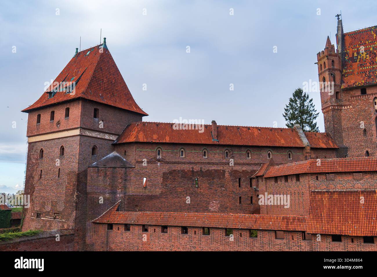 Wide angle view of Malbork Castle shows red brick walls, crenellated ...