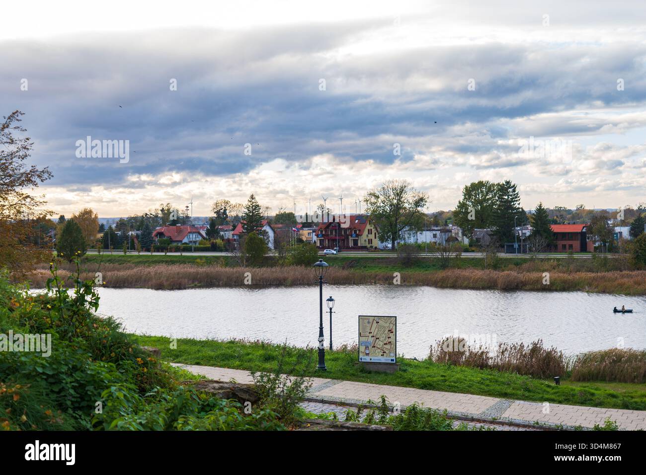Cobbled promenade with lampposts and a map faces a Polish town on the ...