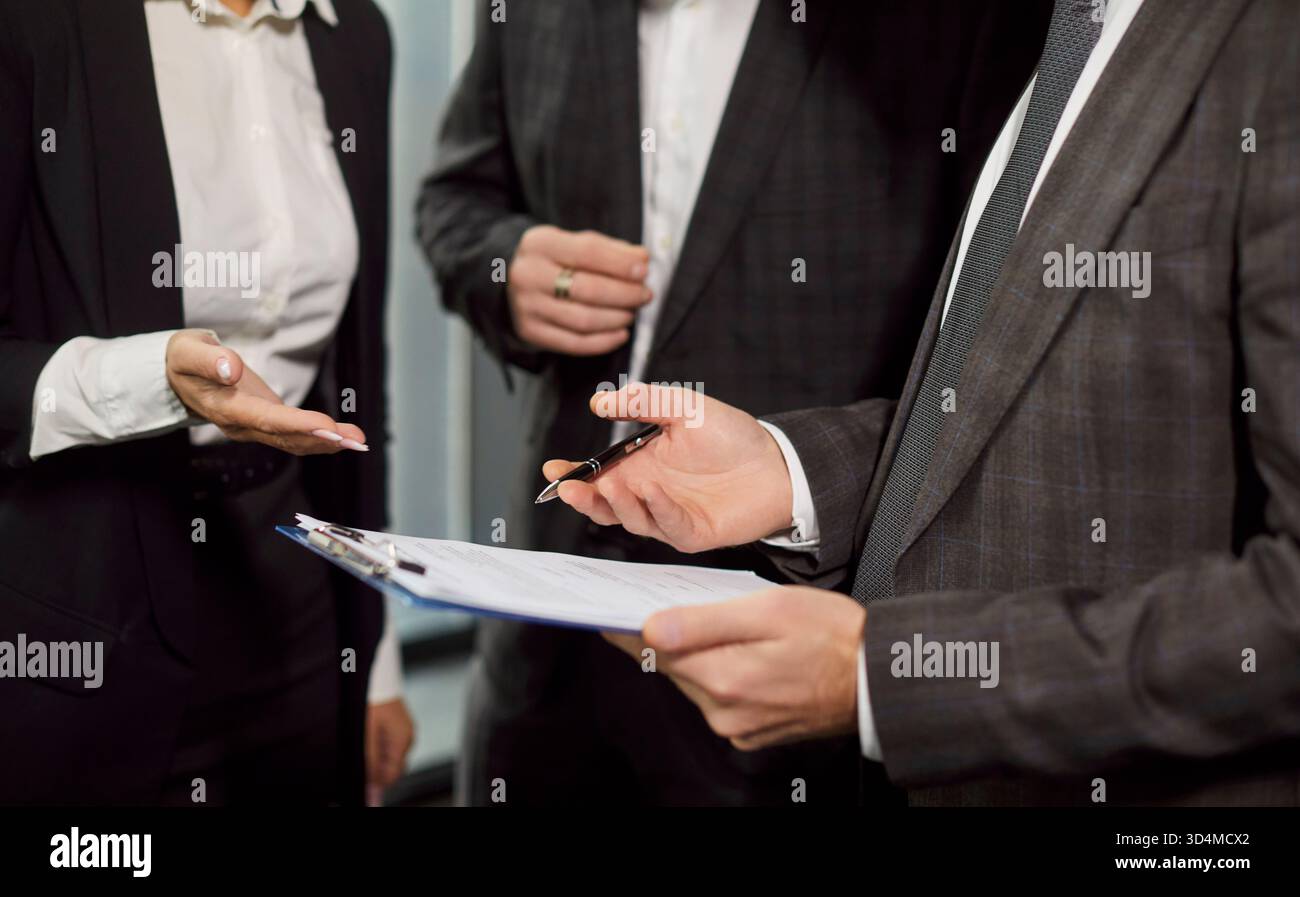 Close-Up Of Coworkers Working Together With Documents Or Contract In ...
