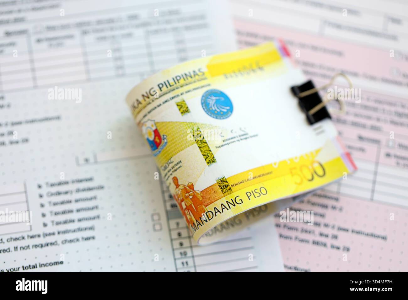 Philippines peso money bills on tax form close up. Taxation and ...
