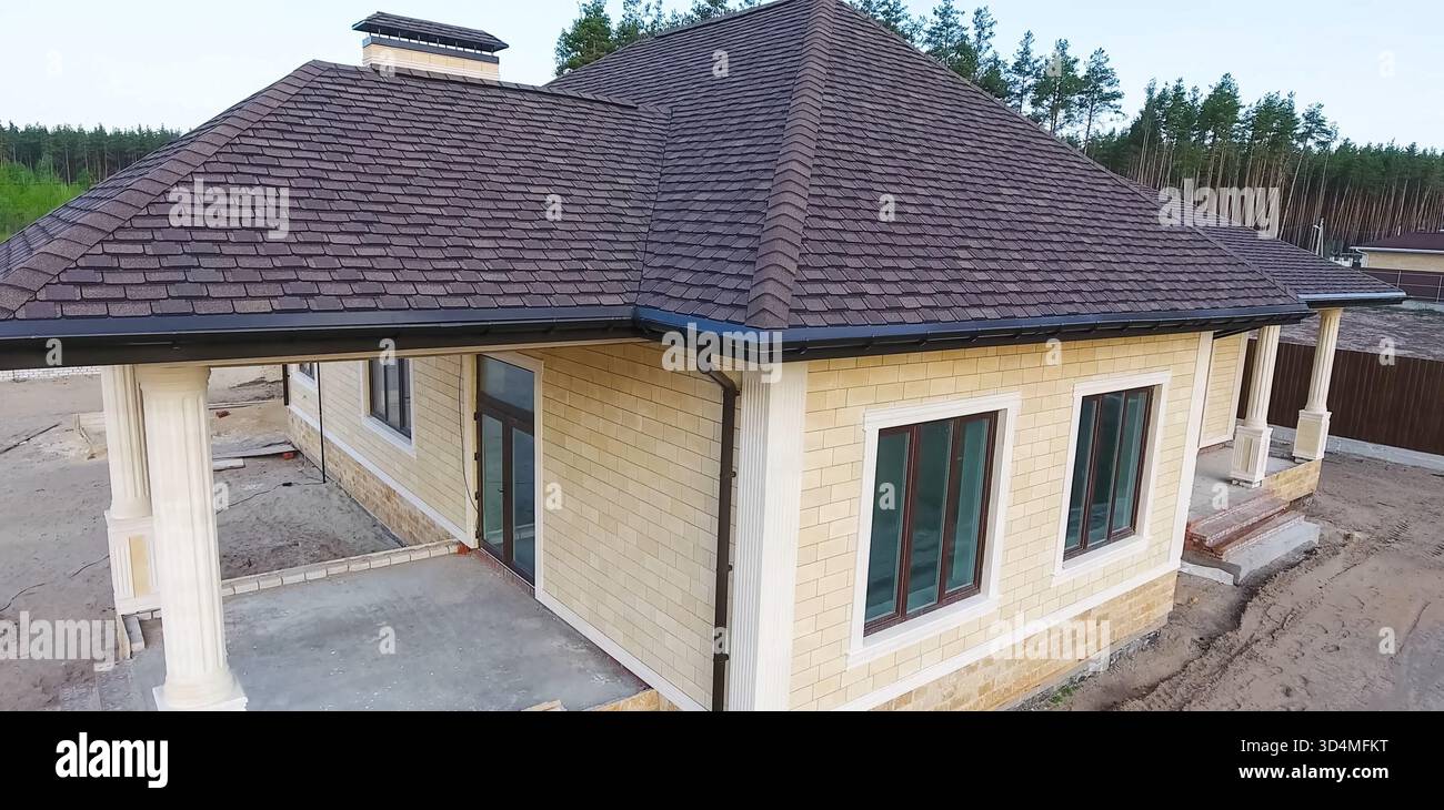 House with a roof from a bituminous tile. Bituminous tile for a roof. a ...