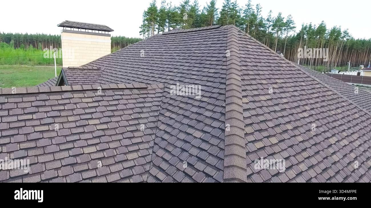 House with a roof from a bituminous tile. Bituminous tile for a roof. a ...