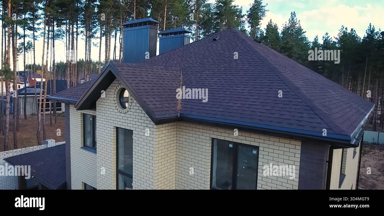 House with a roof from a bituminous tile. Bituminous tile for a roof. a ...
