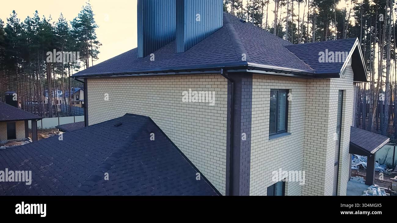 House with a roof from a bituminous tile. Bituminous tile for a roof. a ...