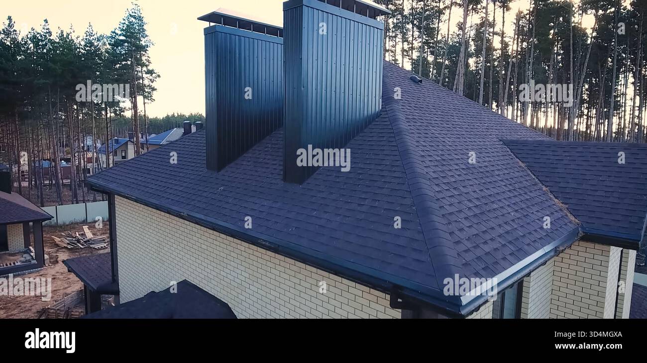 House with a roof from a bituminous tile. Bituminous tile for a roof. a ...