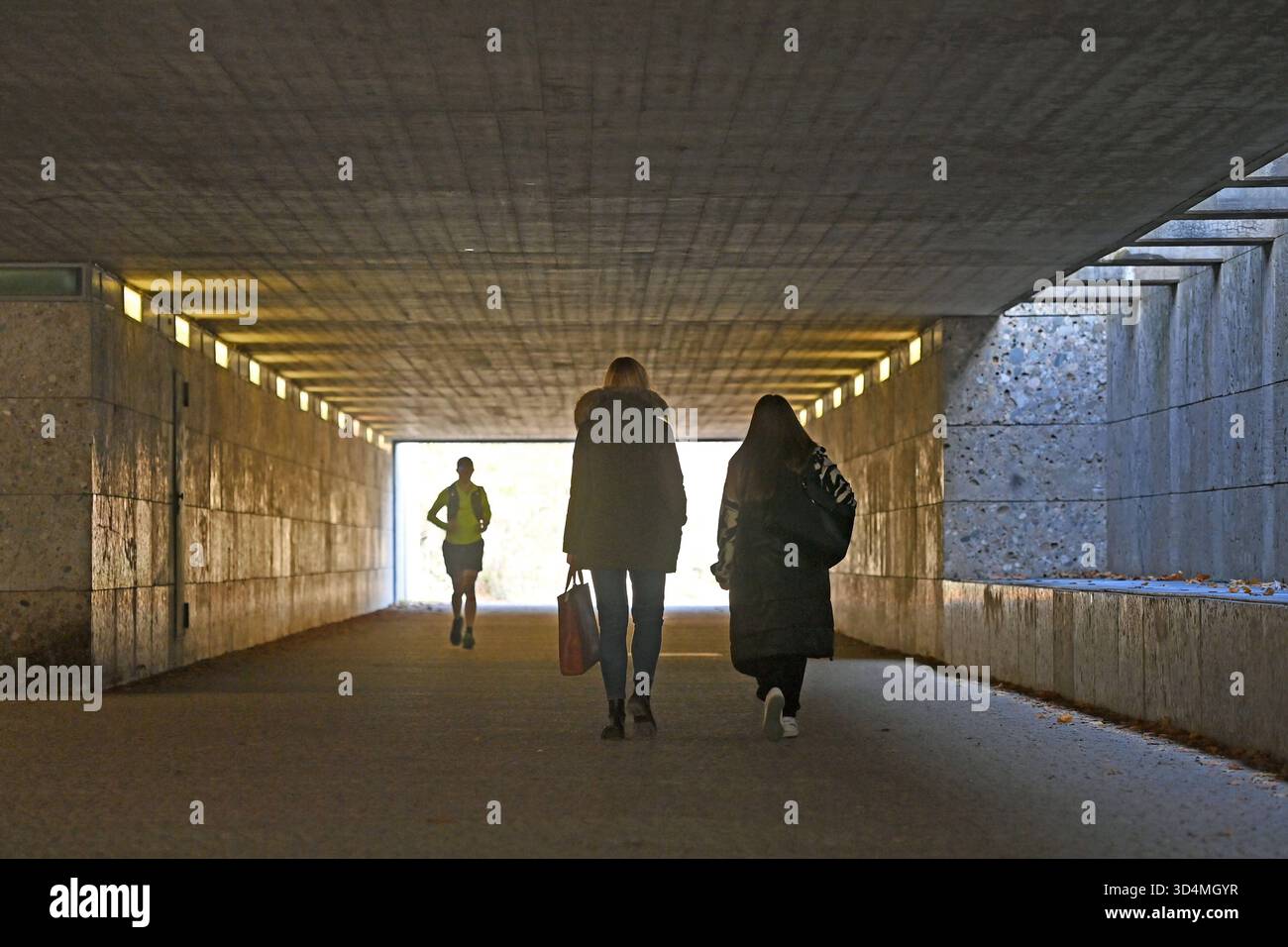 Dunkle Unterfuehrung in Muenchen. Tunnel, Zwei Frauen gehen durch eine ...