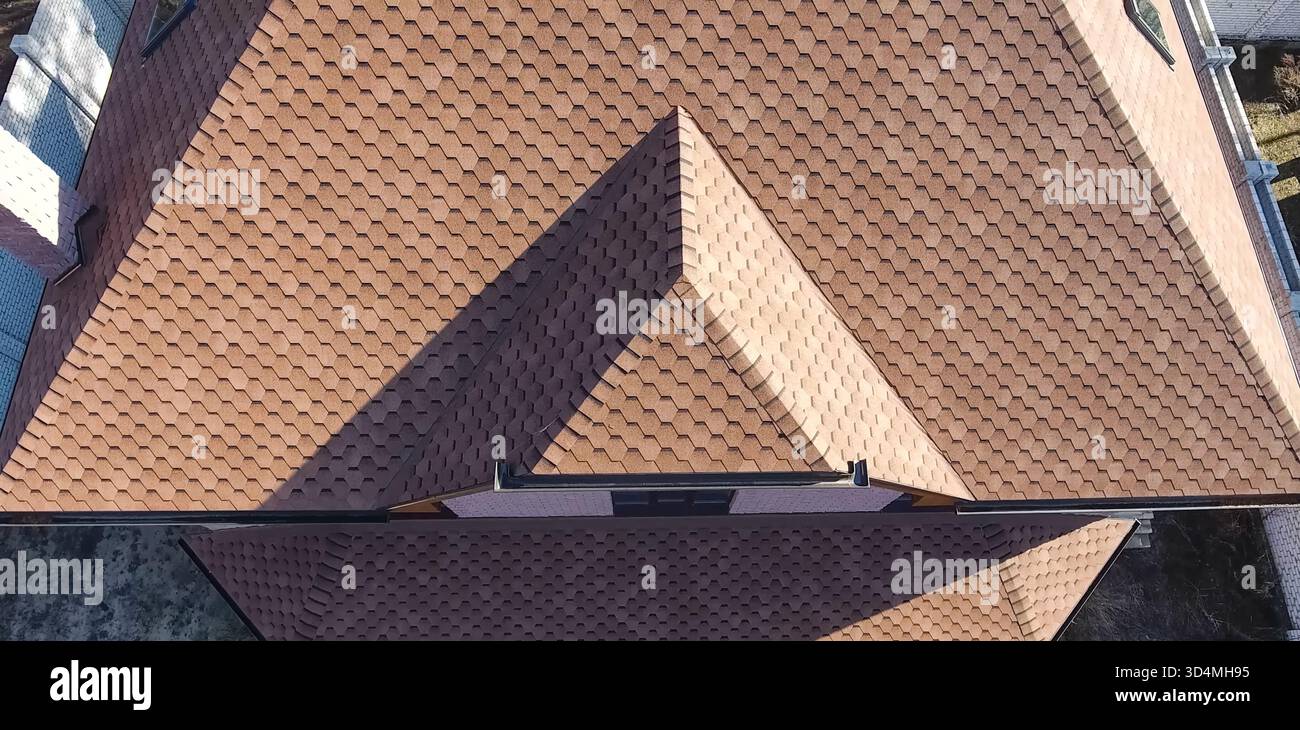 House with a roof from a bituminous tile. Bituminous tile for a roof. a ...